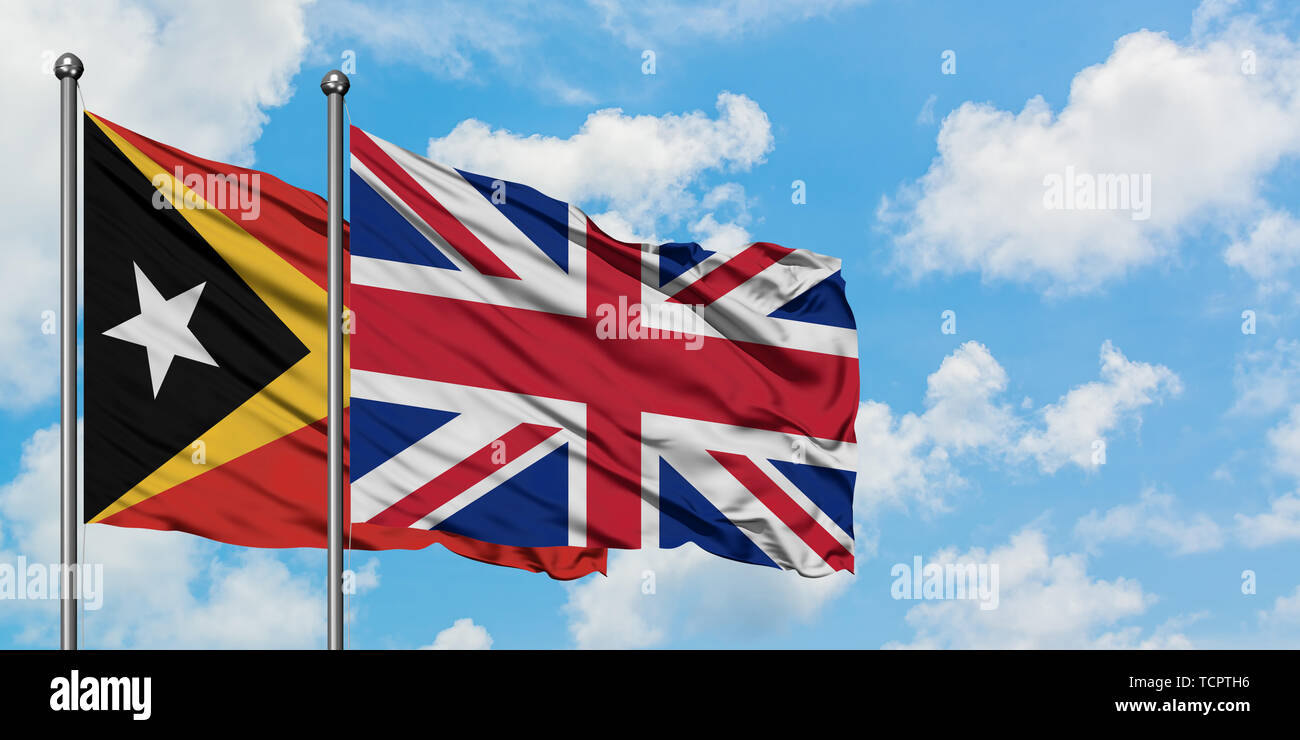 East Timor and United Kingdom flag waving in the wind against white ...