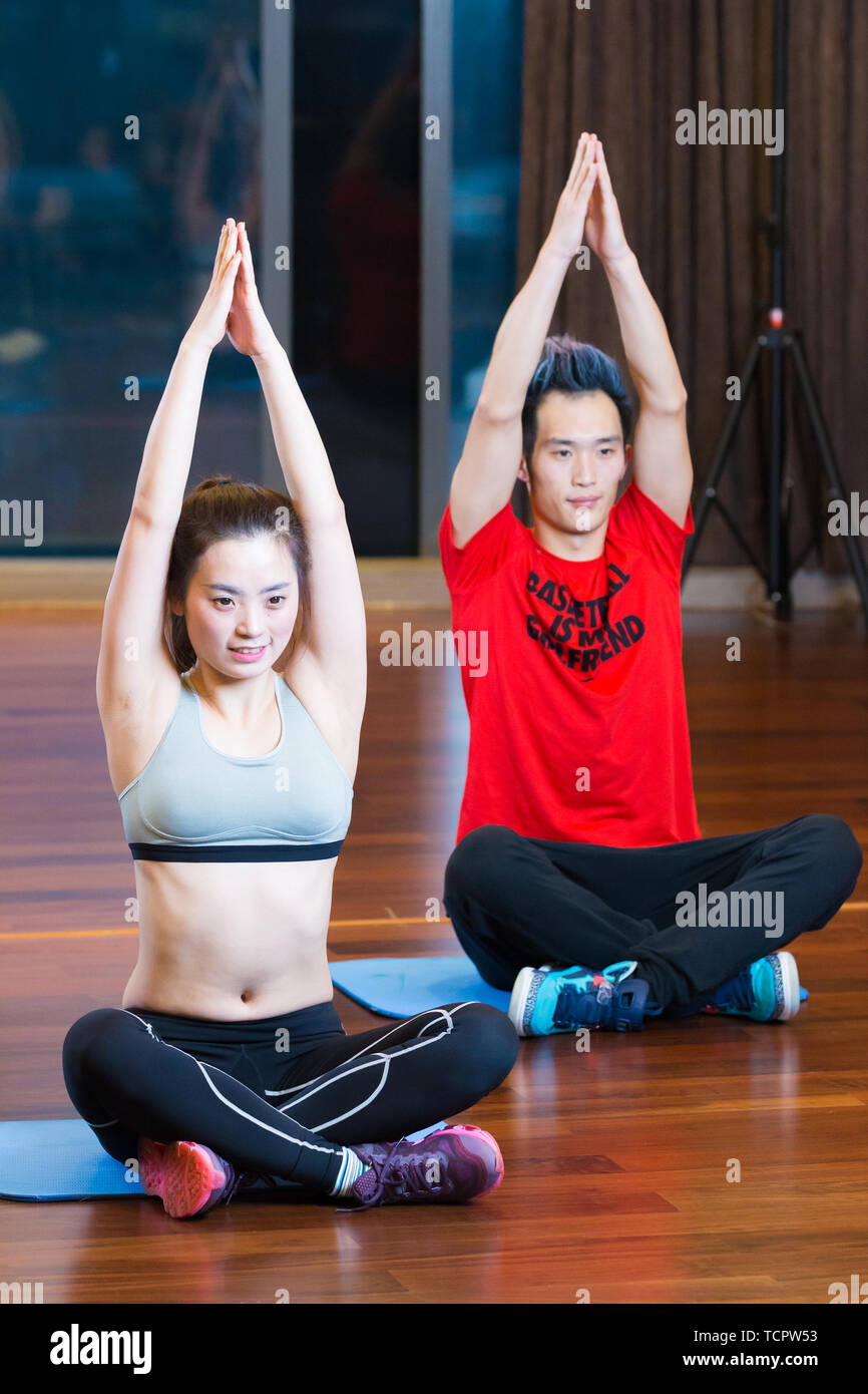 young asian people doing yoga in modern gym Stock Photo - Alamy