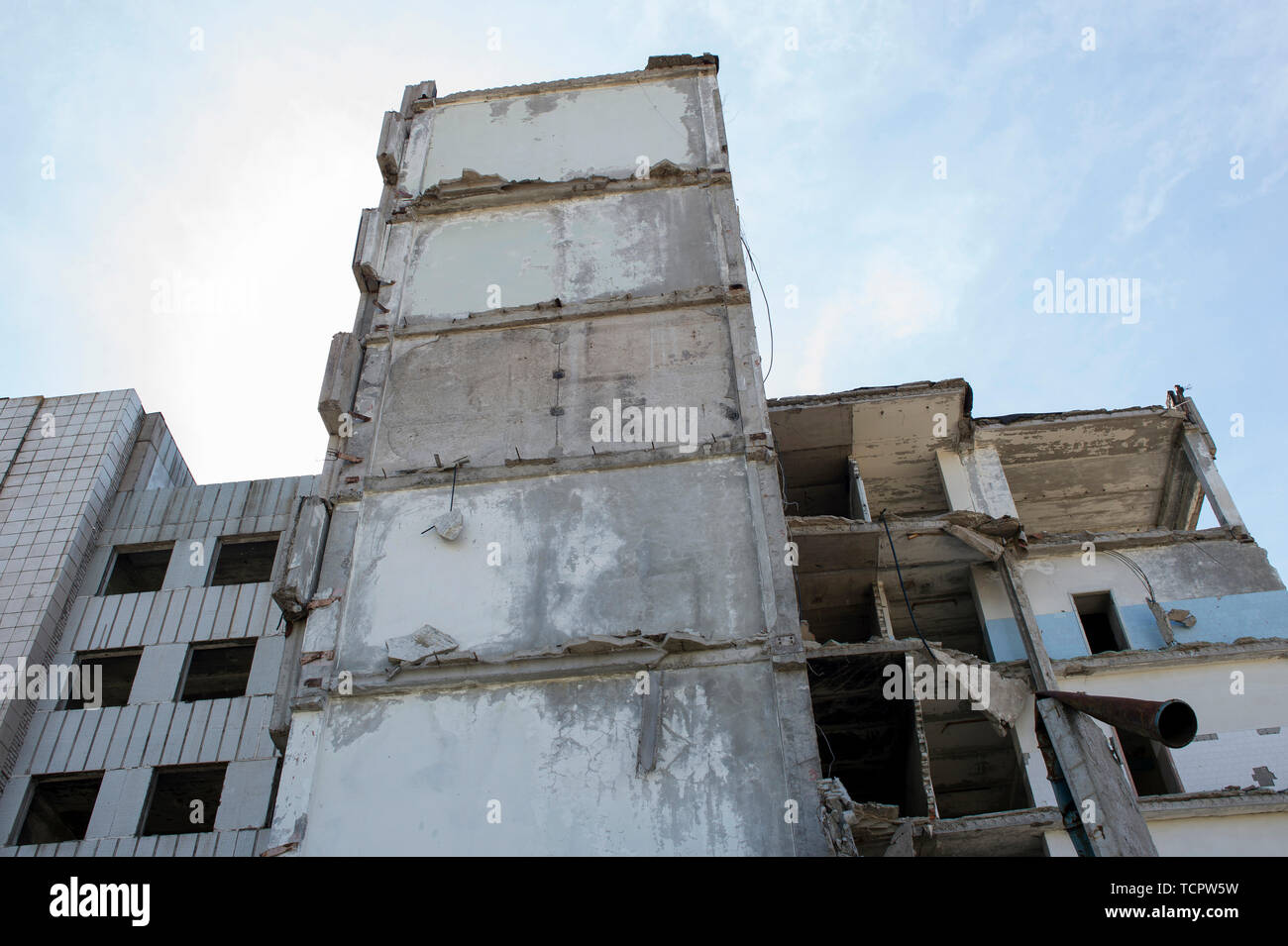 Destroyed large building with no external walls against the blue sky ...