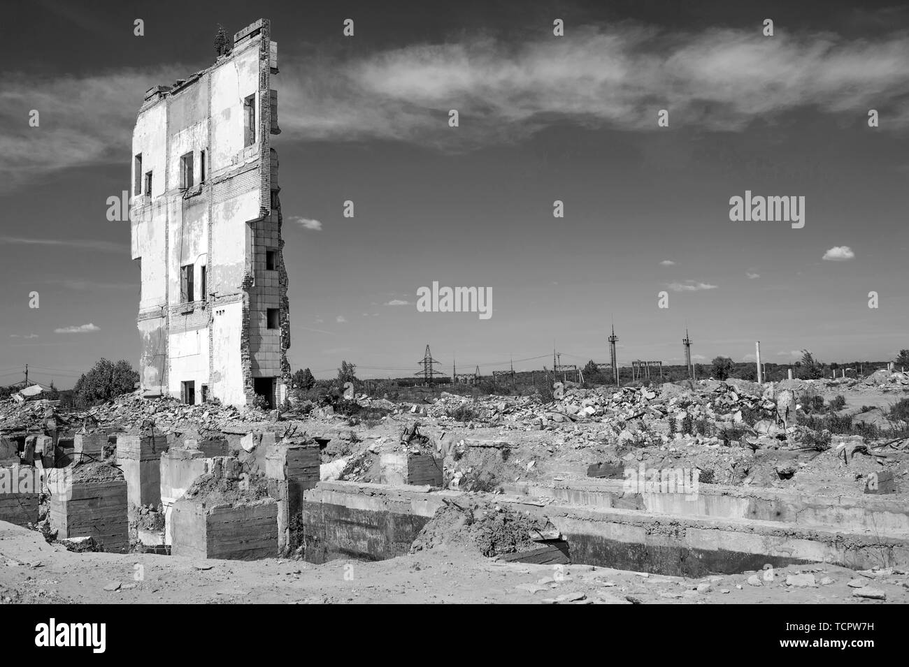 The wall of a destroyed large building with concrete Foundation piles ...