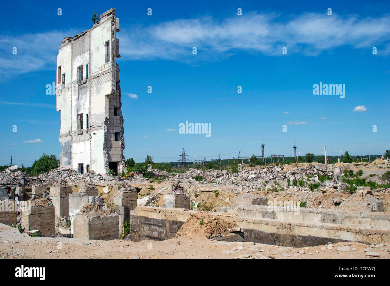The wall of the destroyed big building against the blue sky with ...