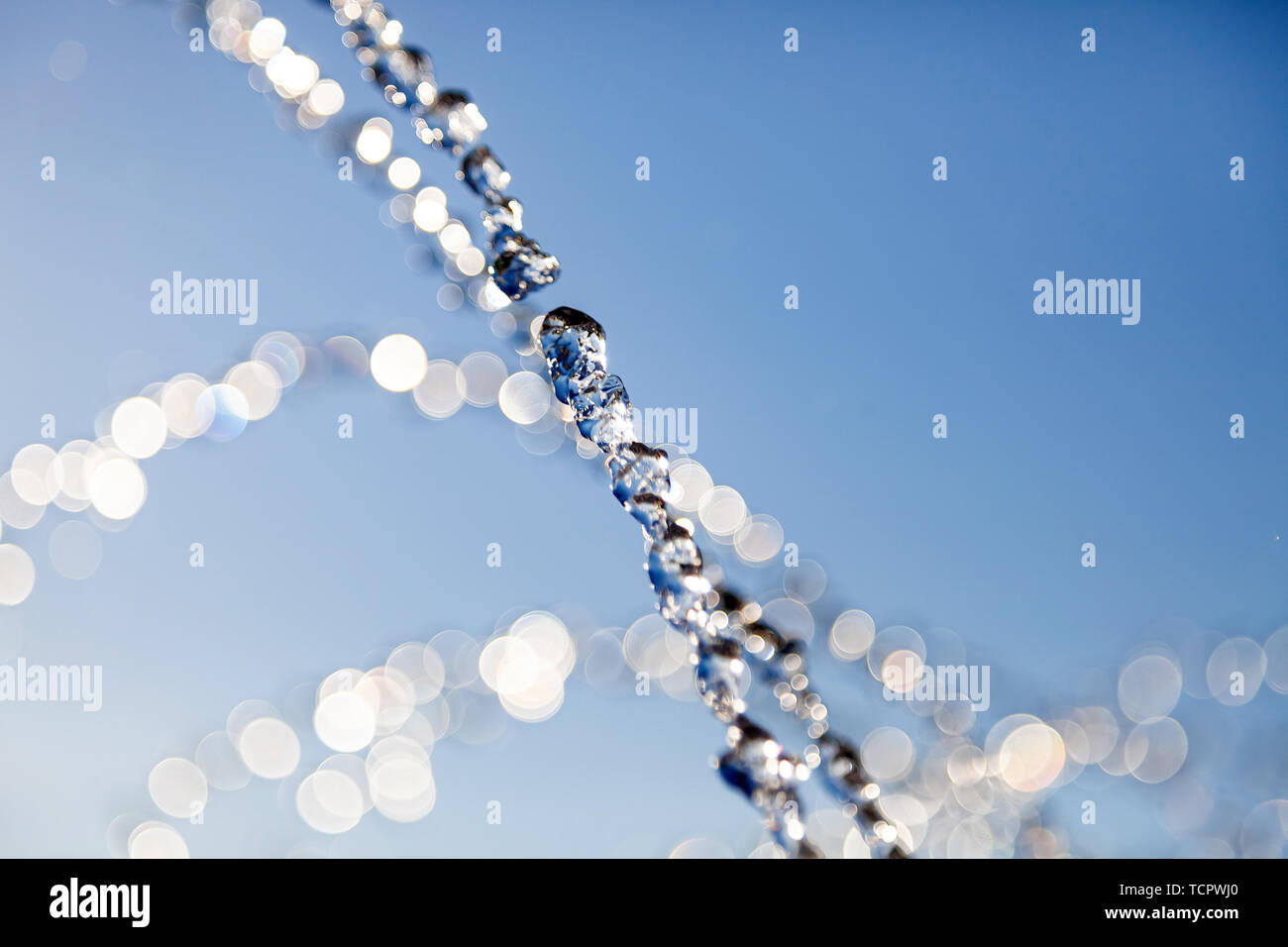 Water droplets frozen in the air with splashes and chain bubbles on a ...