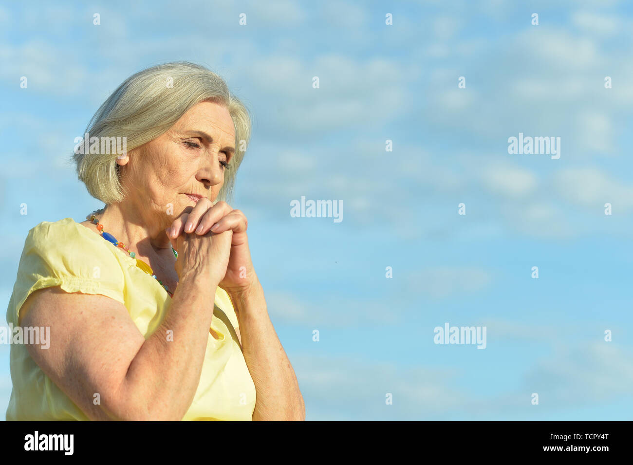 Sad senior beautiful woman posing in spring park Stock Photo - Alamy