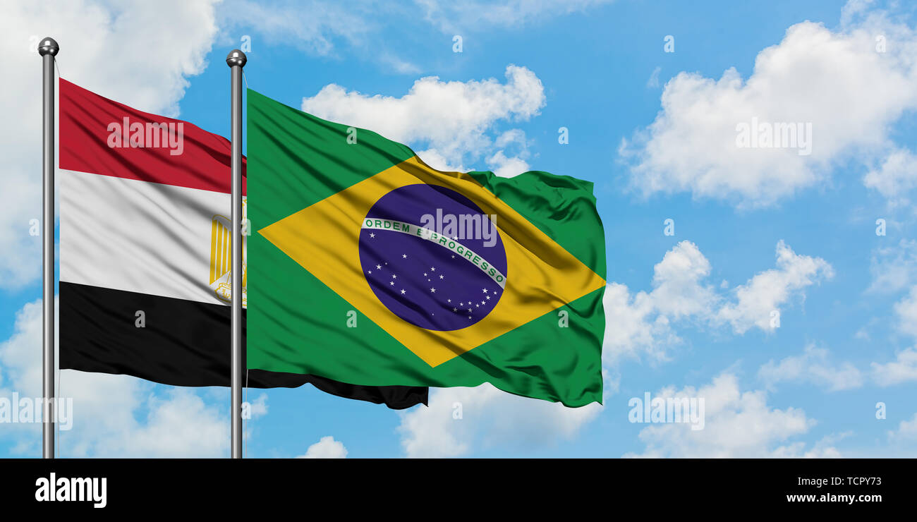 Egypt and Brazil flag waving in the wind against white cloudy blue sky ...
