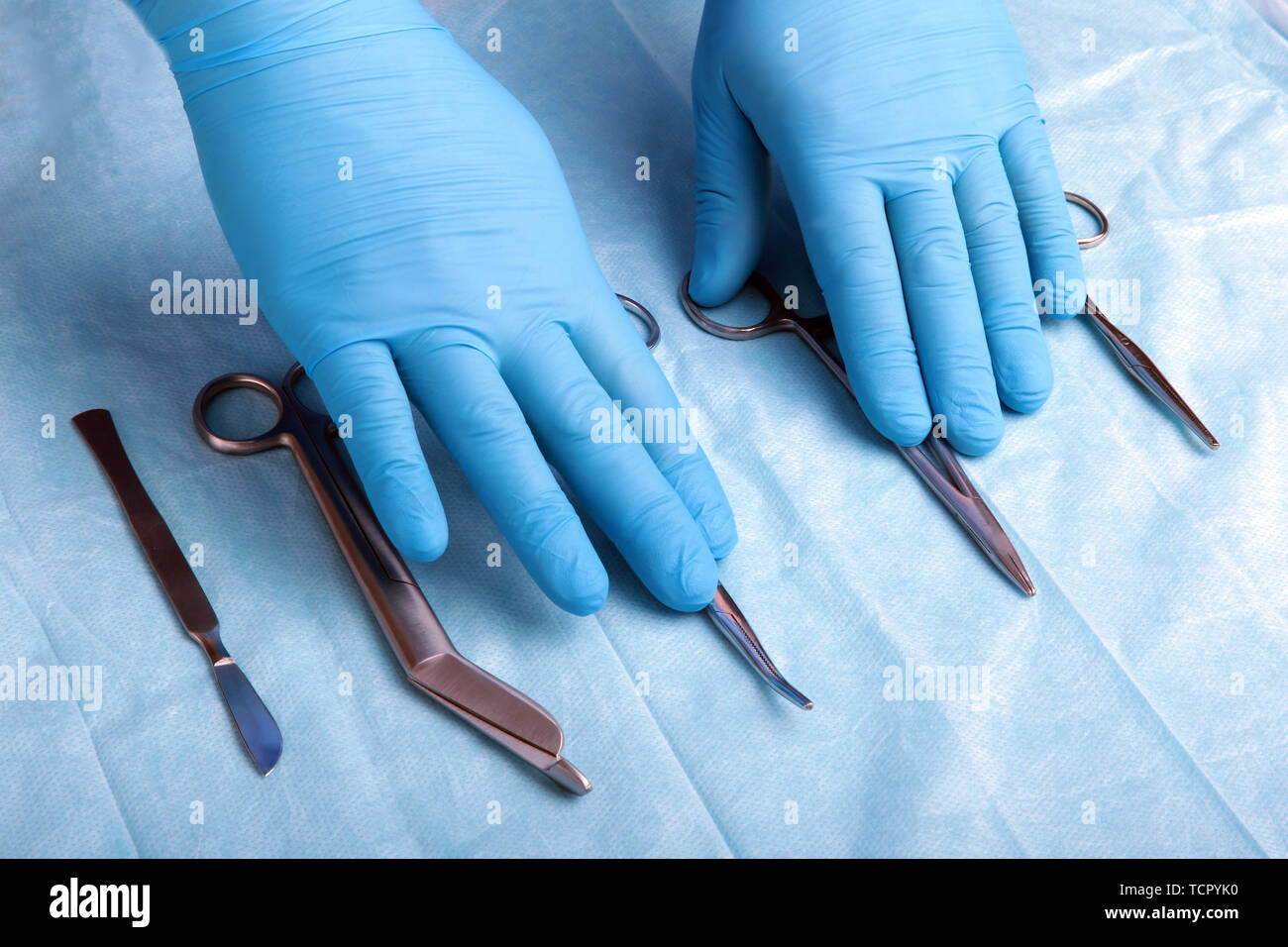 Detail shot of sterilized surgery instruments with a hand grabbing a ...