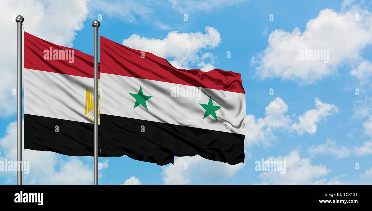 Egypt and Syria flag waving in the wind against white cloudy blue sky ...