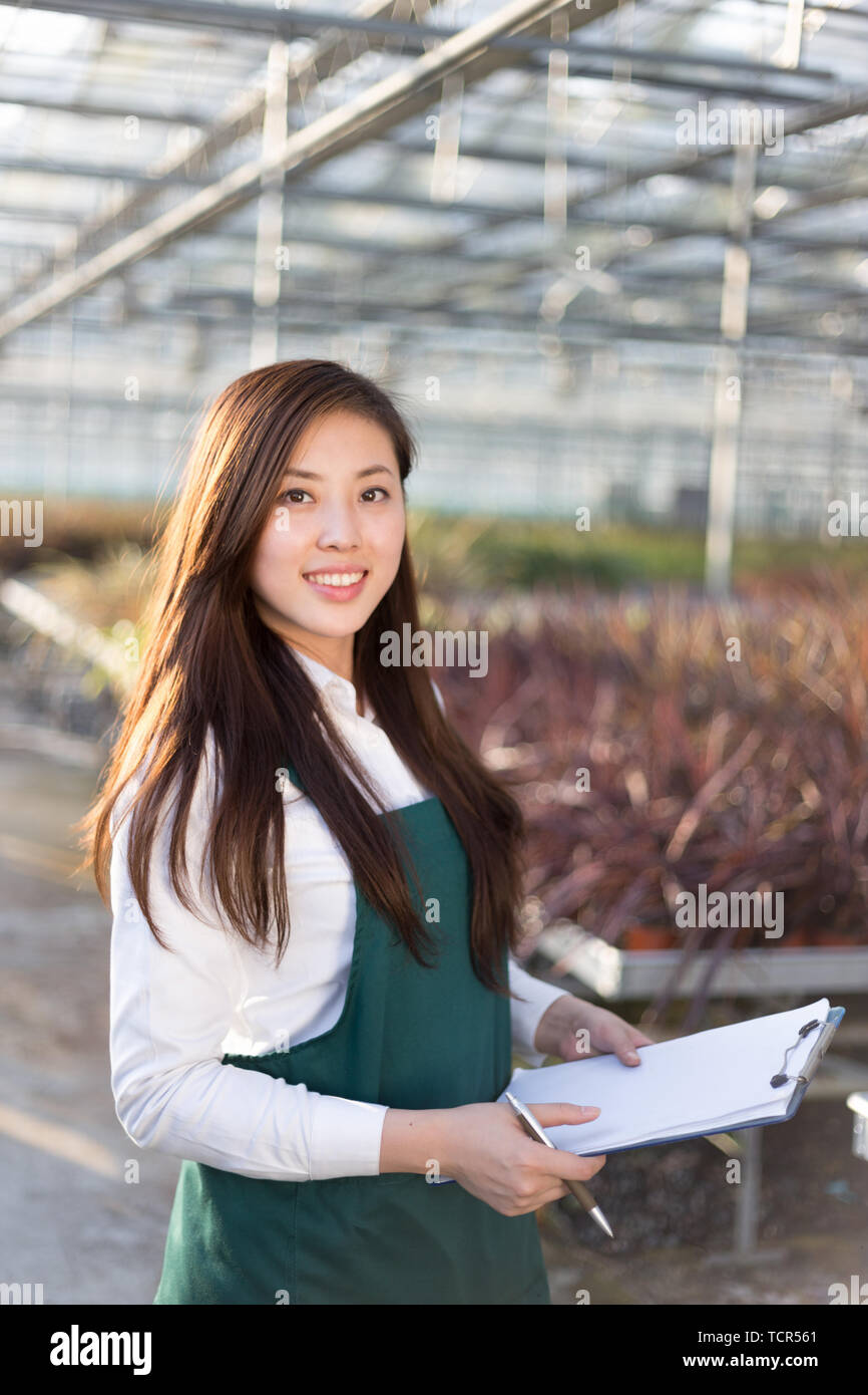 young beautiful chinese woman works in modern green house Stock Photo ...