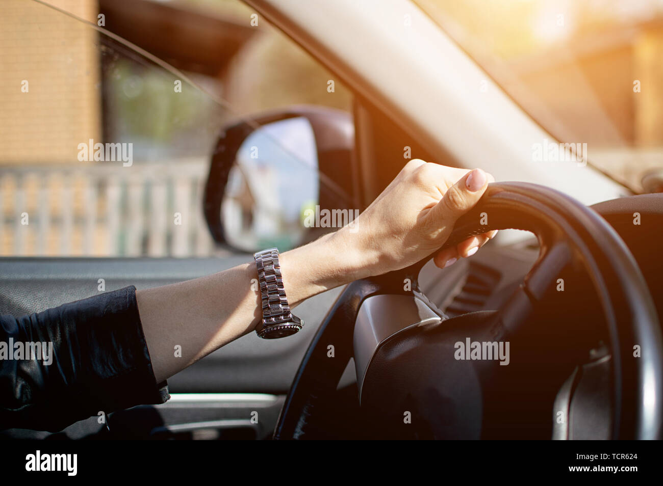 female hand with a clock. female hands on the steering wheel in the car ...