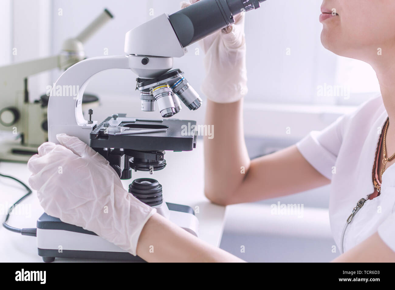 Hands with microscope in the laboratory to study viruses and microbes ...