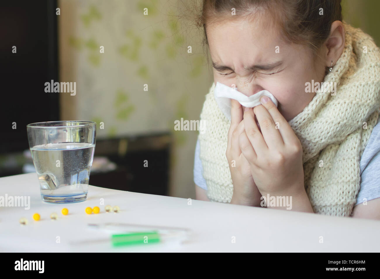 little girl in a room in a scarf with a throat wound with a temperature ...