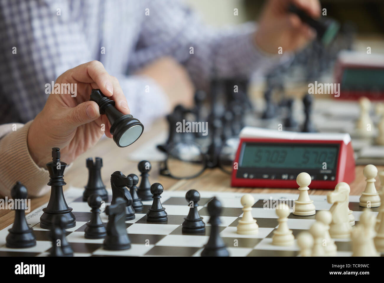 Two chess players sitting in a row and making synchronous chess move ...