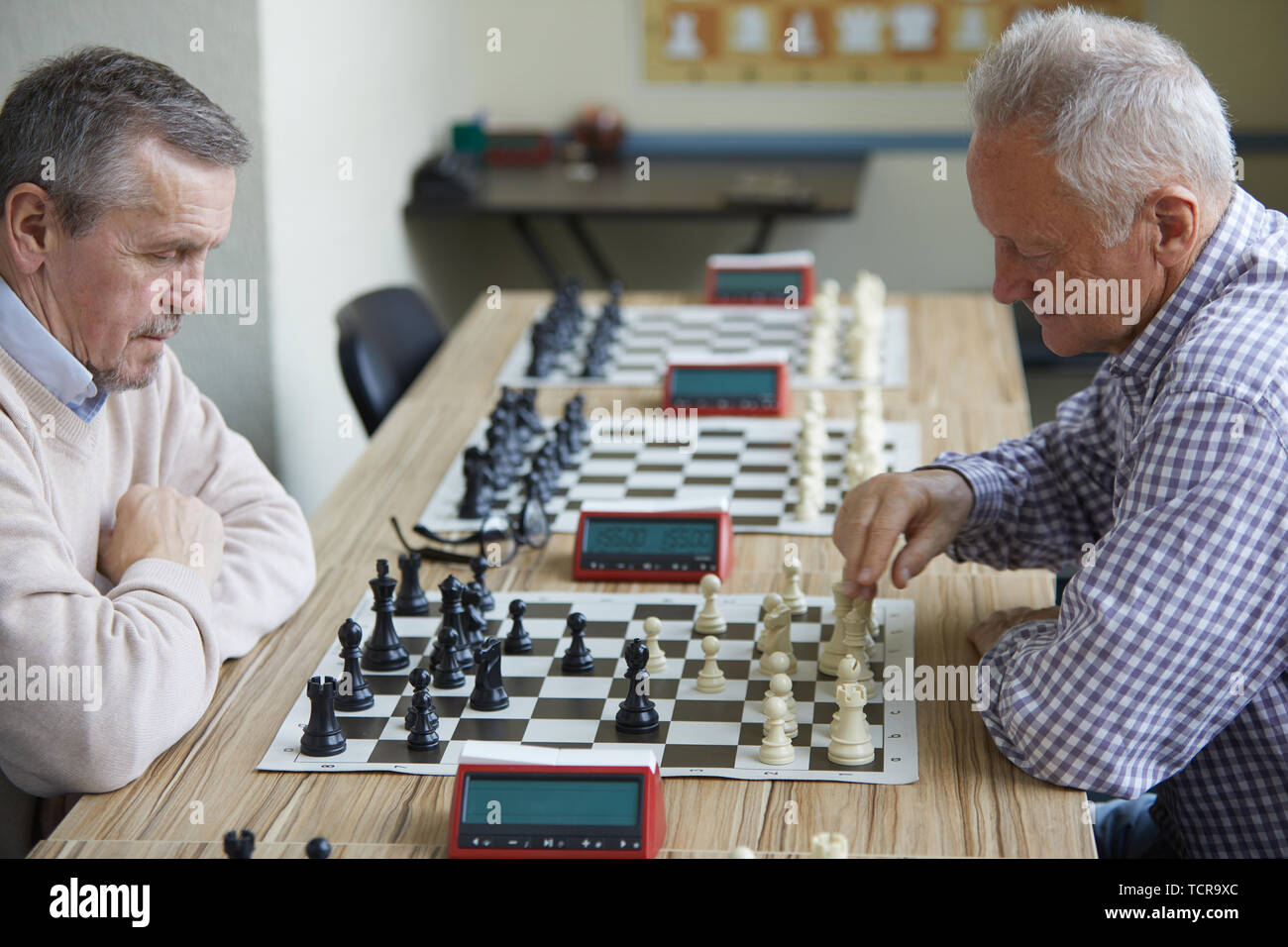 Two aged experienced chess players with silver hair playing chess at ...