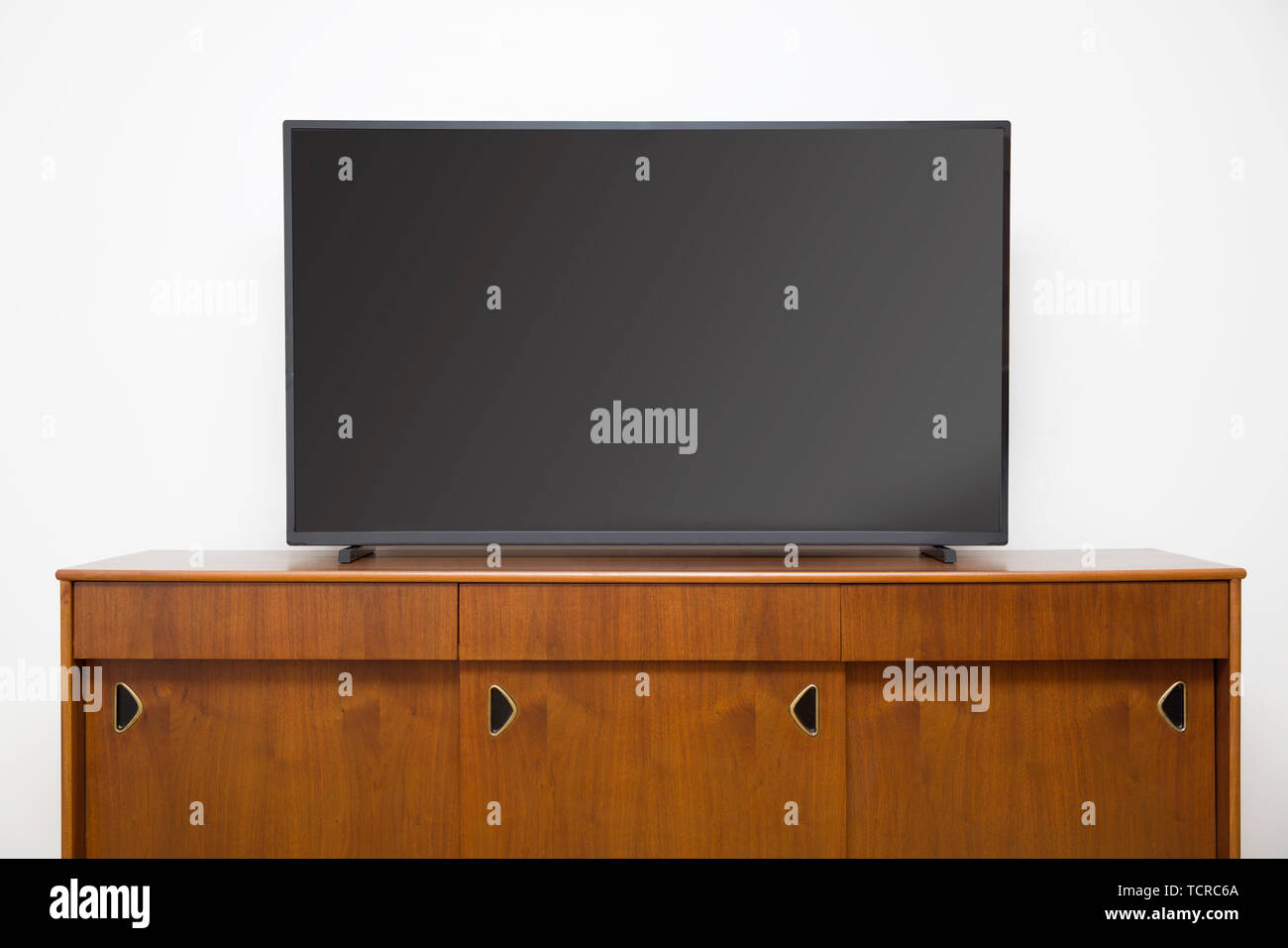 Modern TV set with empty blank screen on the wooden cabinet in front of ...