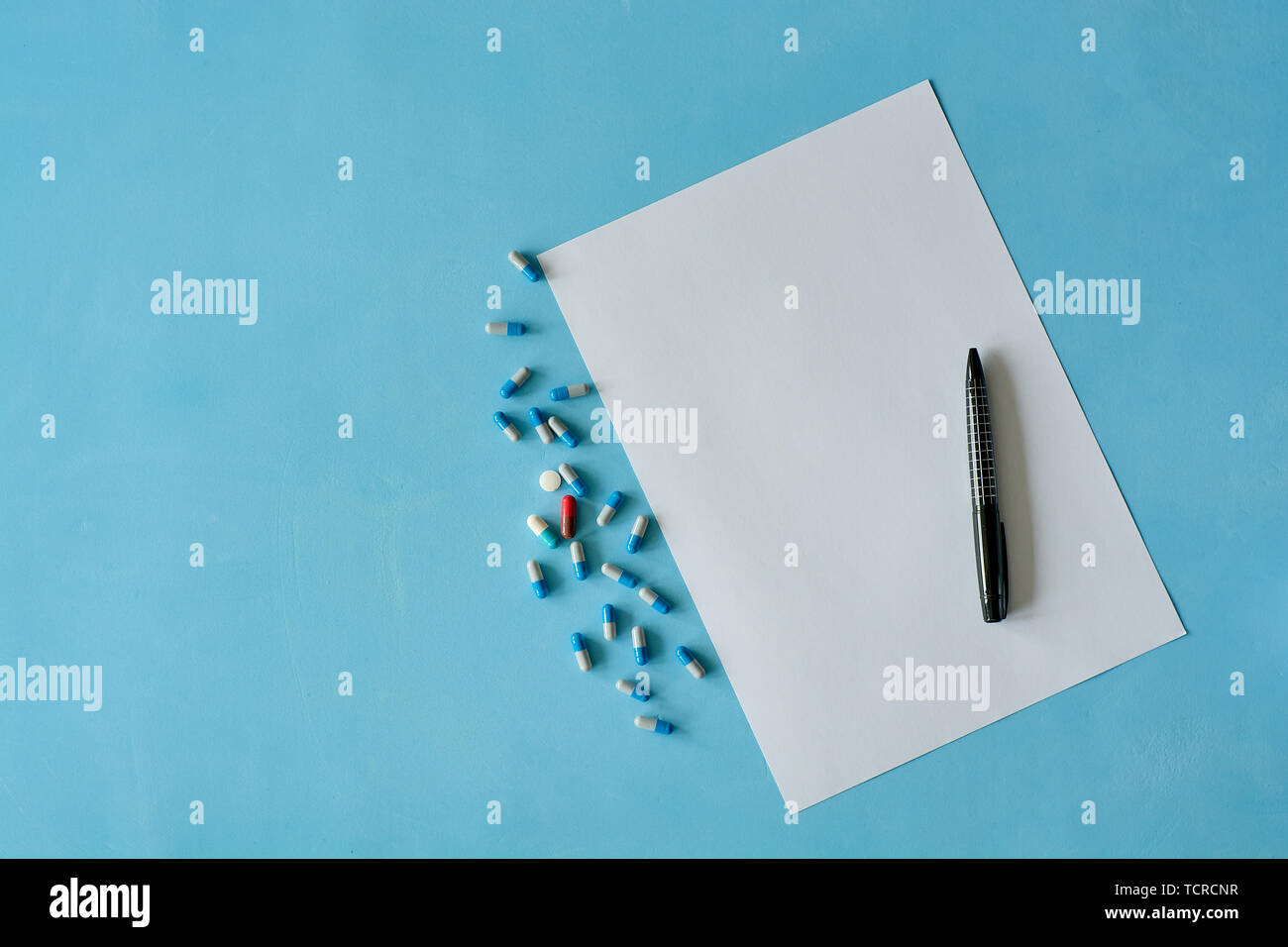 White sheet paper with black pen and colored different pills, capsules ...