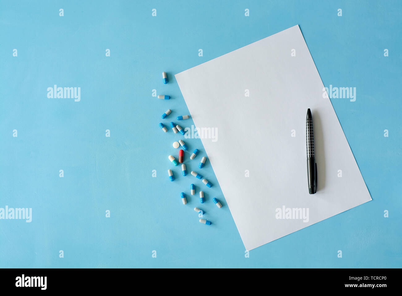 White sheet paper with black pen and colored different pills, capsules ...