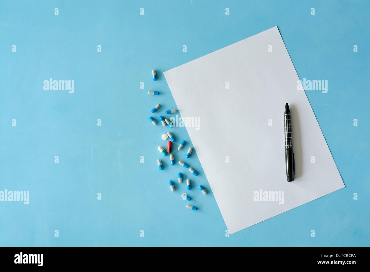 White sheet paper with black pen and colored different pills, capsules ...