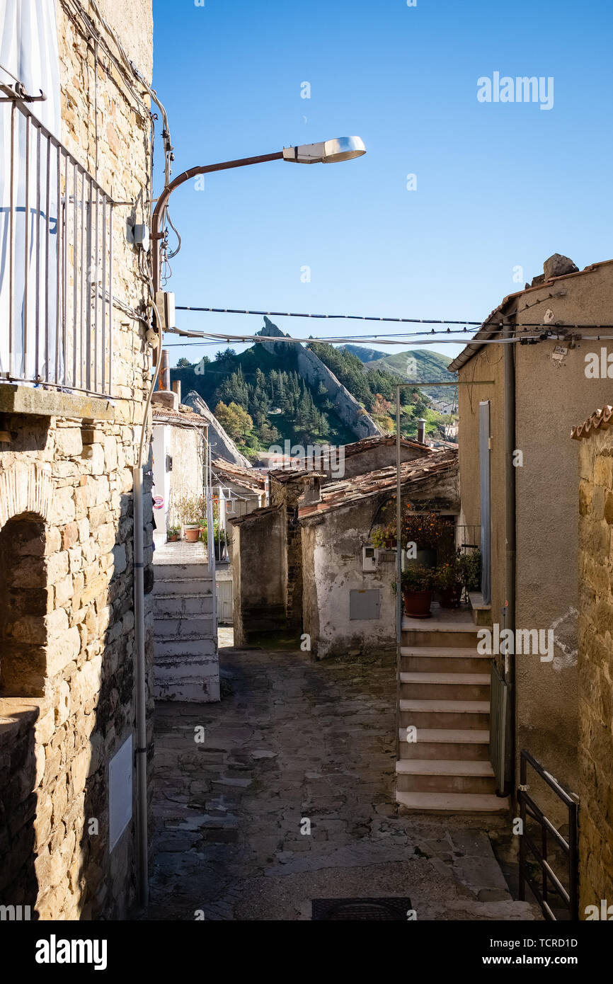 Ancient alley in Pietrapertosa village. In the background, Dolomites of ...