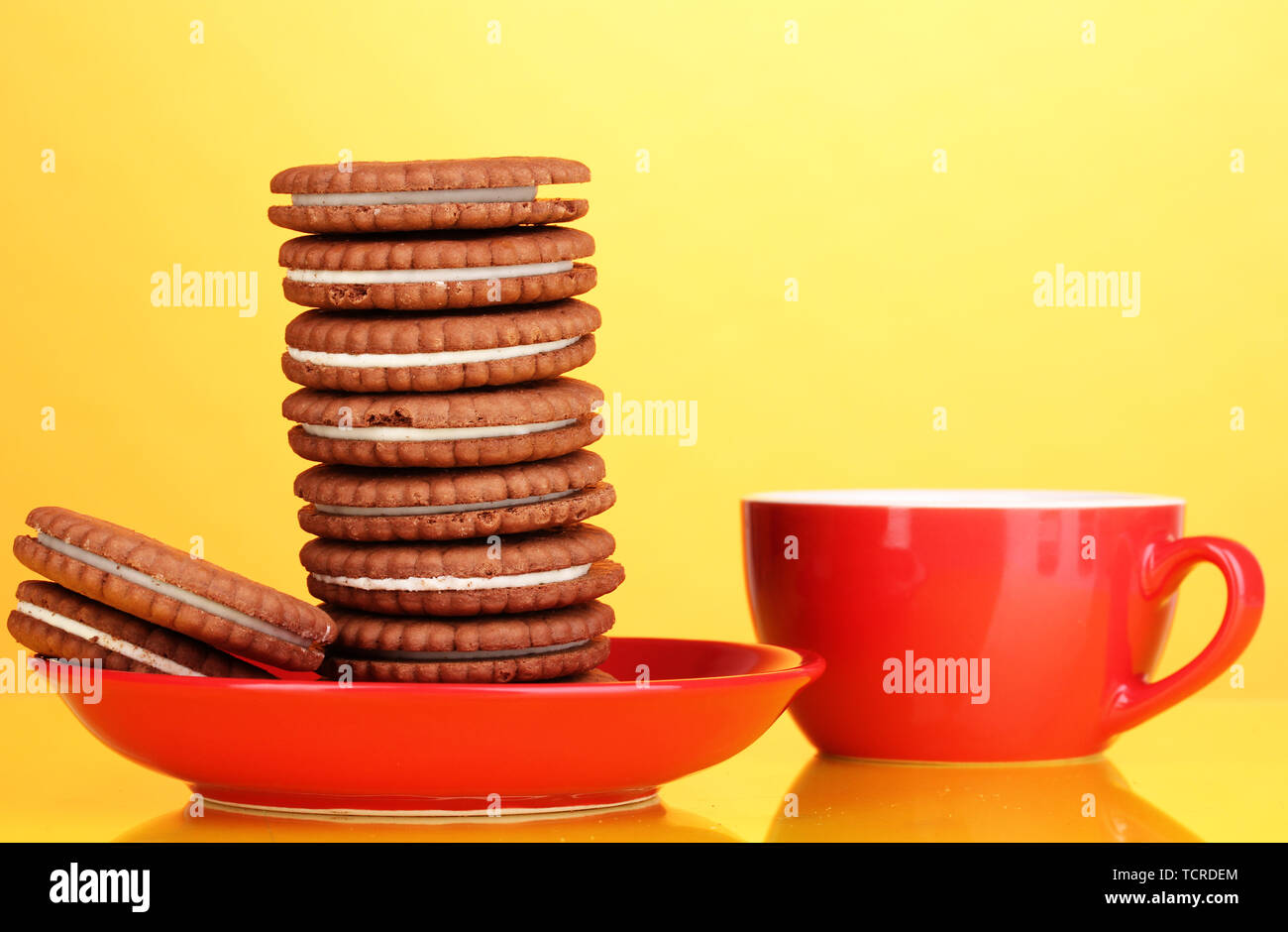 Chocolate cookies with creamy layer on red plate yellow background ...