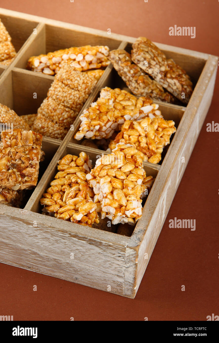 tasty sweets (kozinaki)in wooden crate on brown background Stock Photo ...