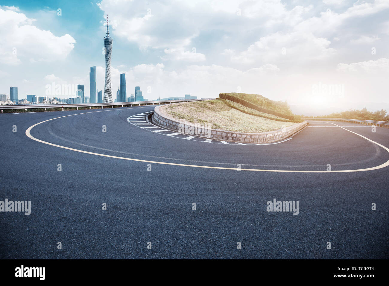 empty asphalt sharp turn with modern city Stock Photo - Alamy