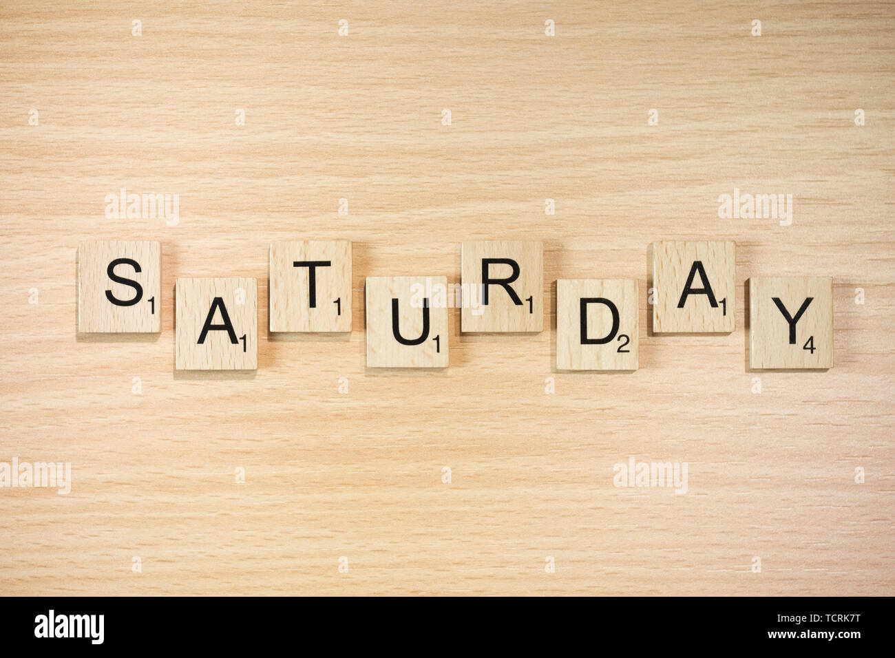 The word Saturday, spelt out using wooden tiles on a wood effect ...