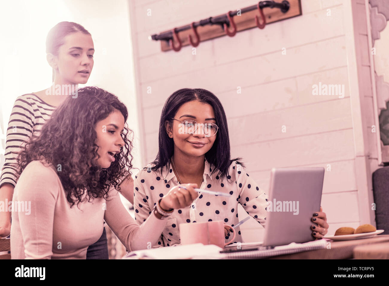 Three creative and inspired art students watching educational video ...