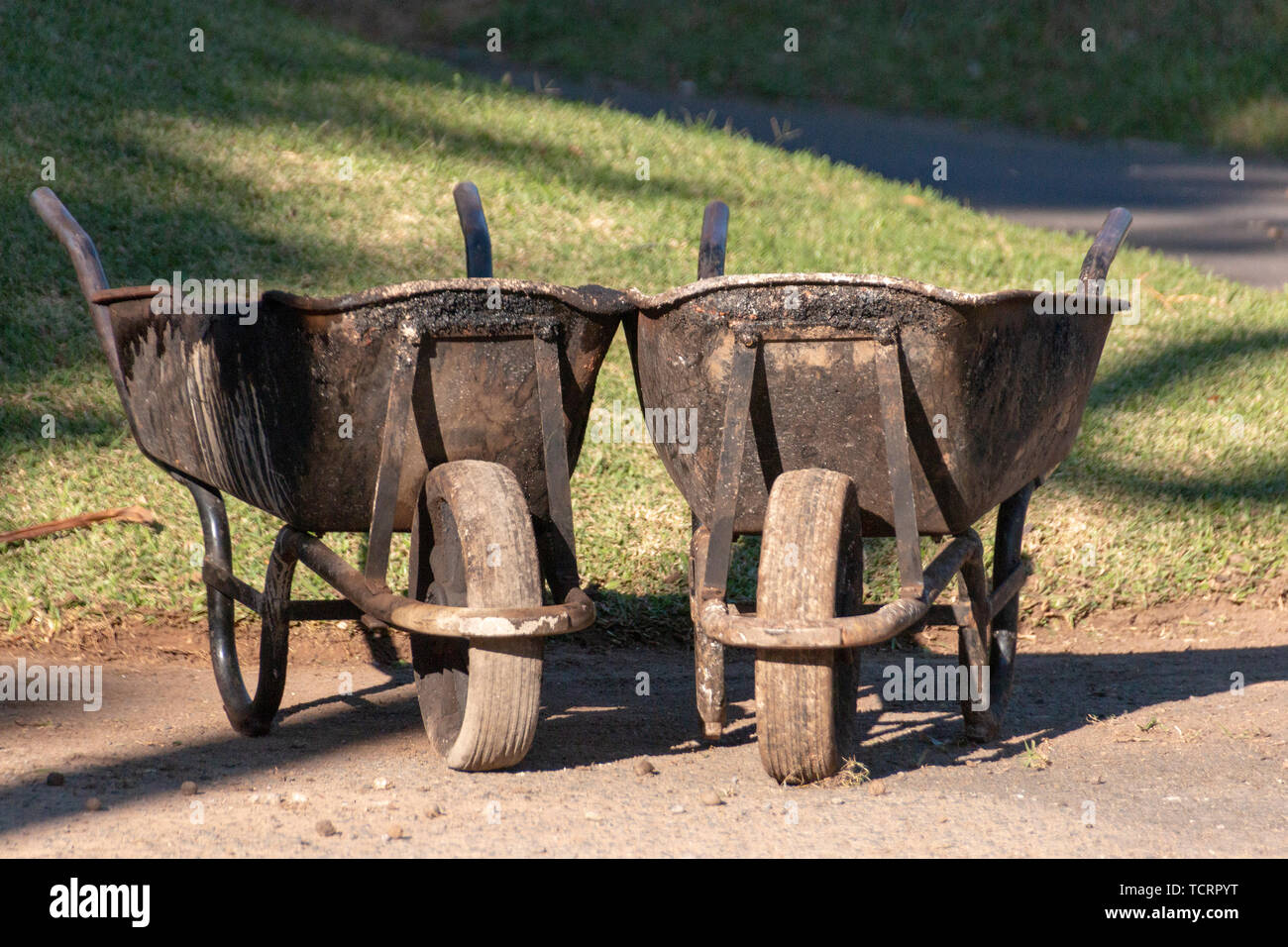 A close up front view of two old work wheel barrows Stock Photo - Alamy