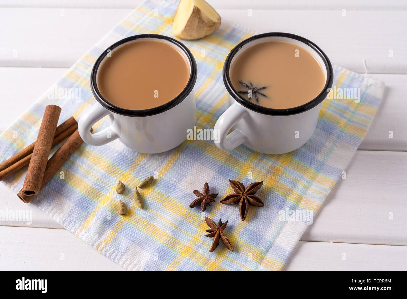 Indian traditional Masala chai tea in a mugs and kitchen herbs, over ...