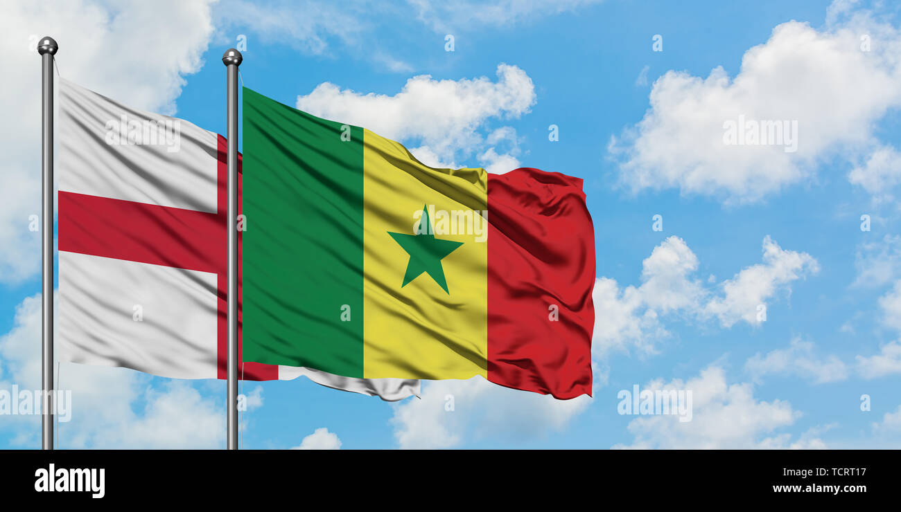 England and Senegal flag waving in the wind against white cloudy blue ...