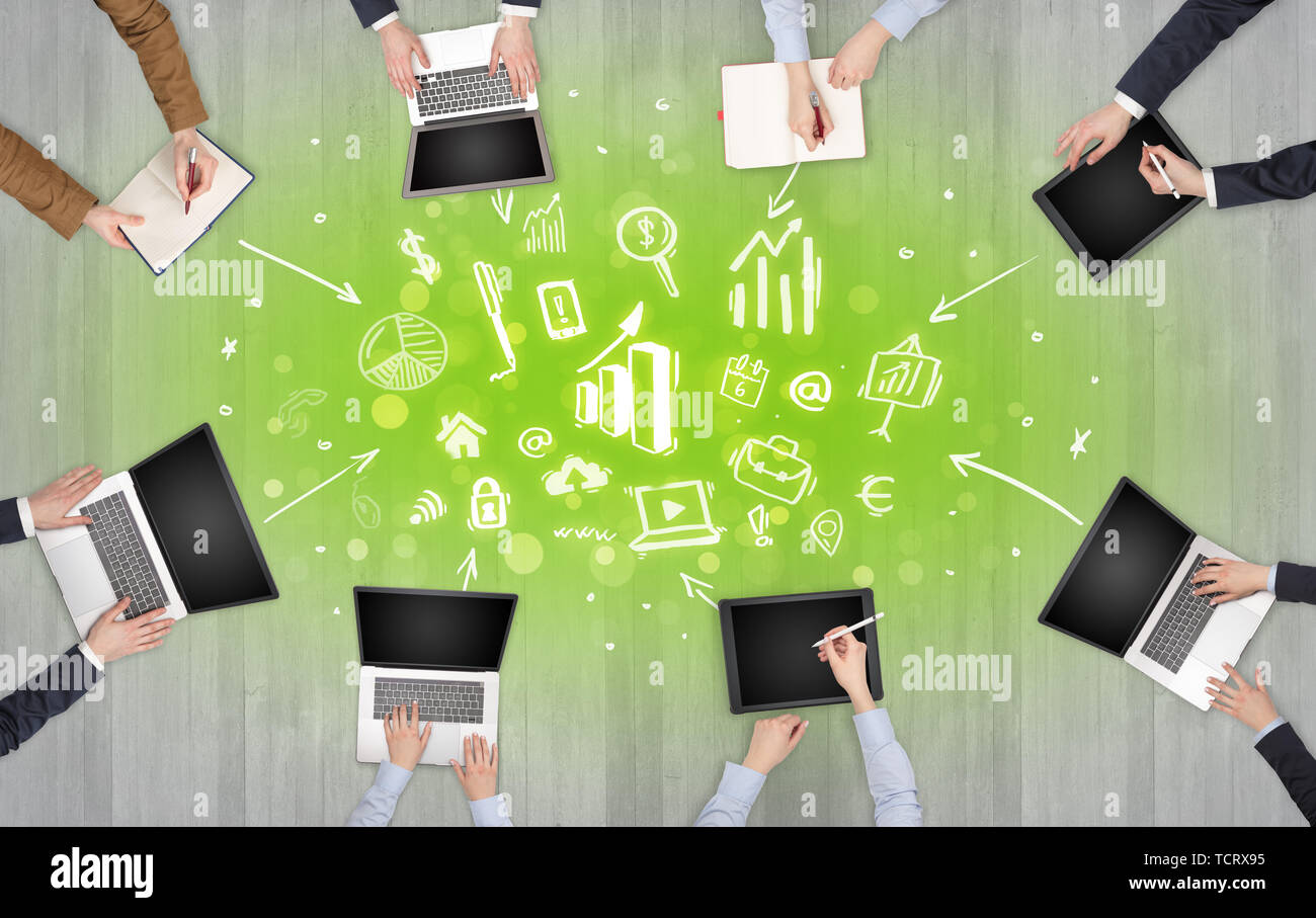 Group of people with devices in hands making reports together on laptop ...