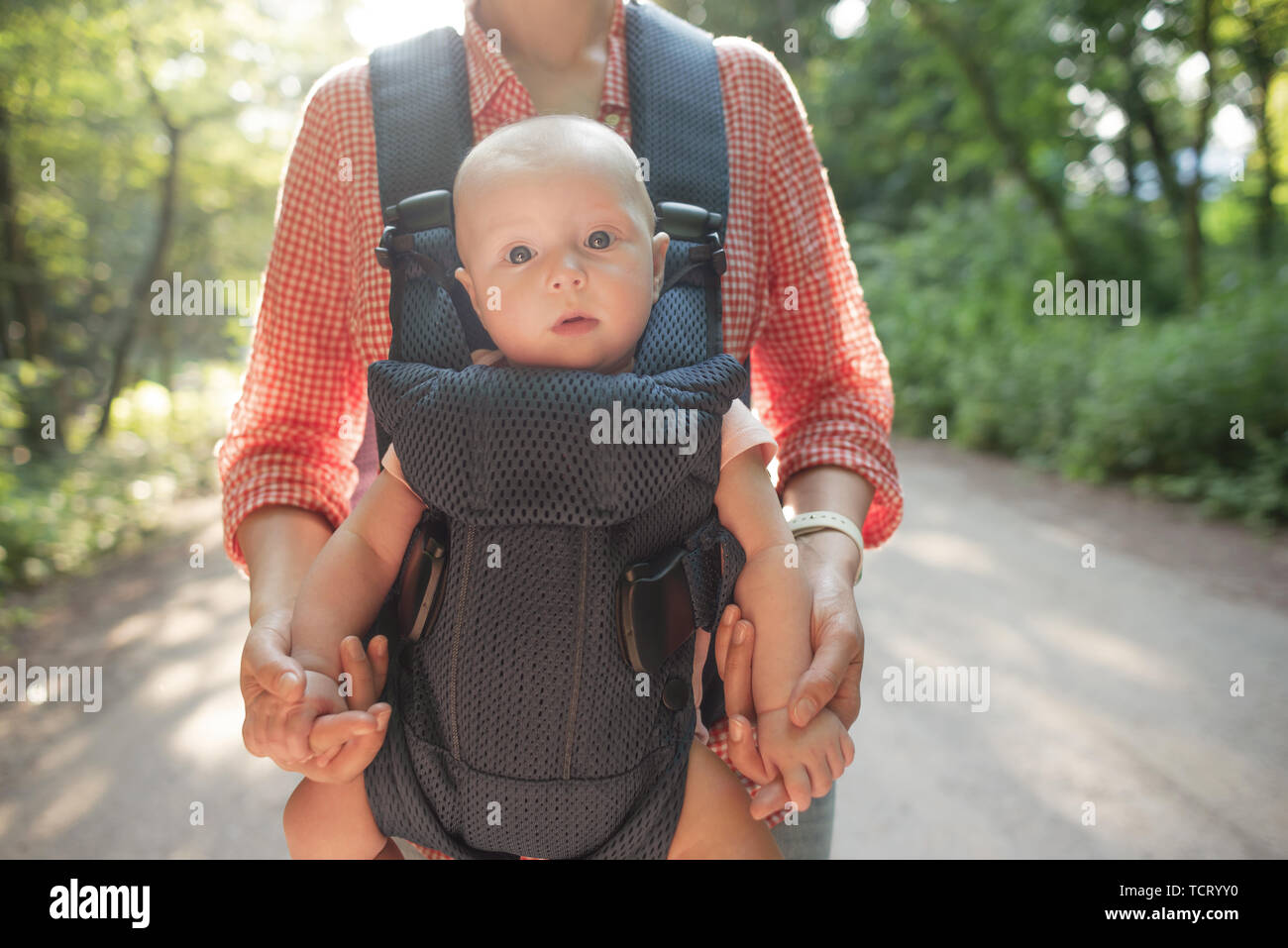Baby girl in a backpack carrying her mother on the body. Travel with ...