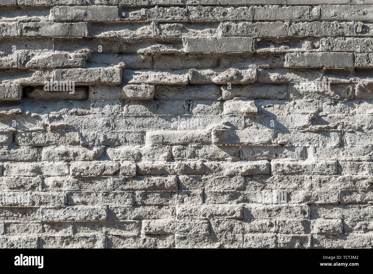 Gray old brick walls, mottled surfaces eroded by wind and rain ...