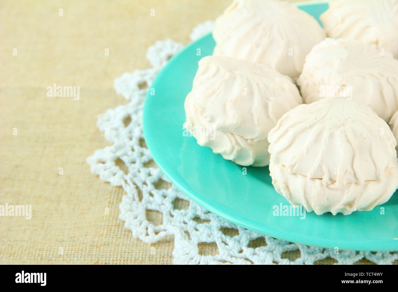 Marshmallows on color plate on light background Stock Photo - Alamy
