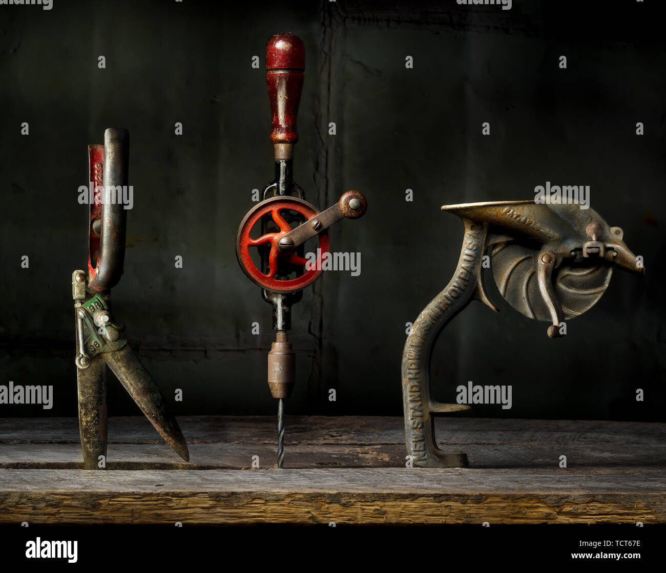 Three old tools--clippers, hand drill, and cherry stoner--on display ...