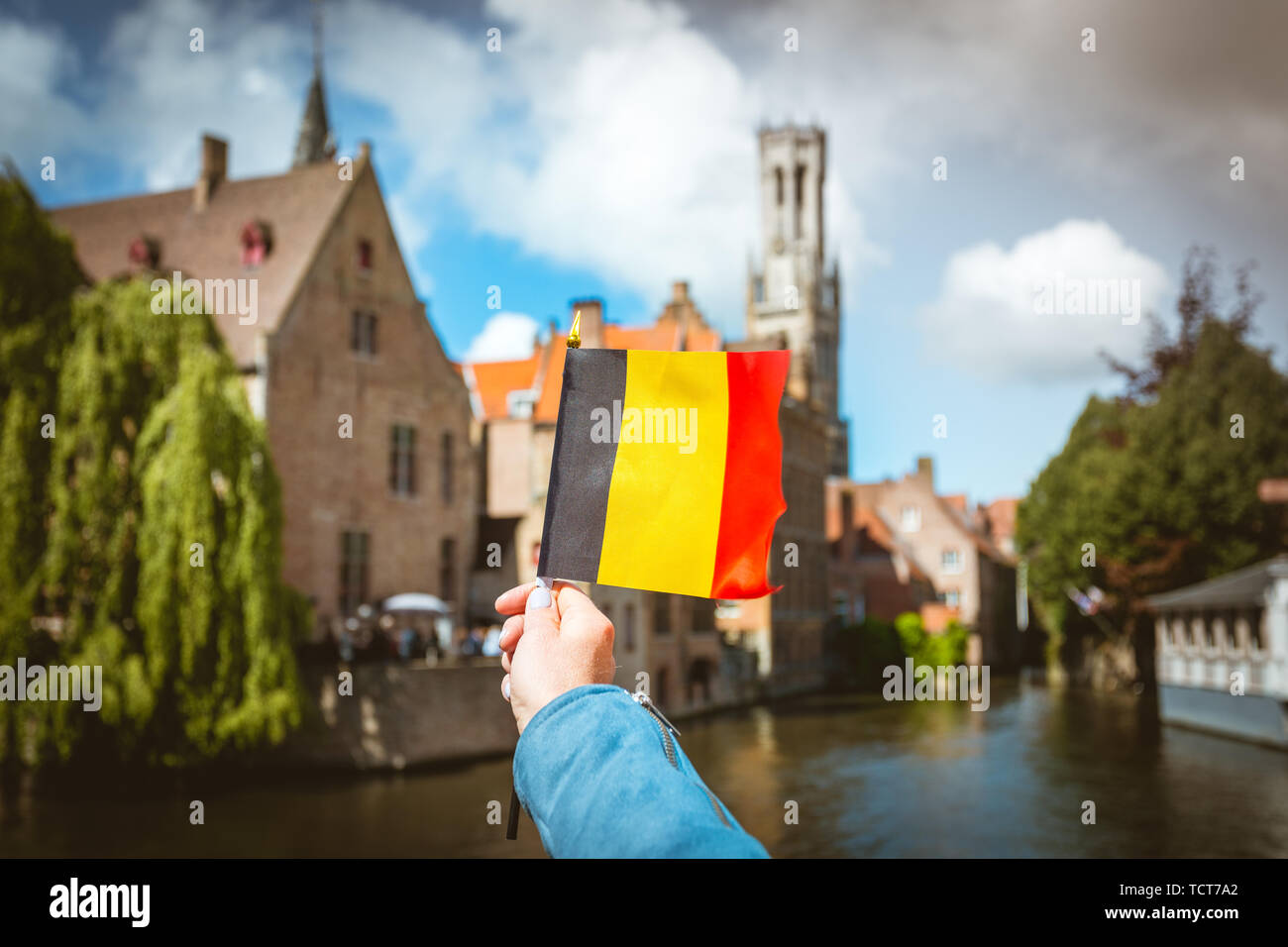 Flag of Belgium against the background of attractions in Bruges ...
