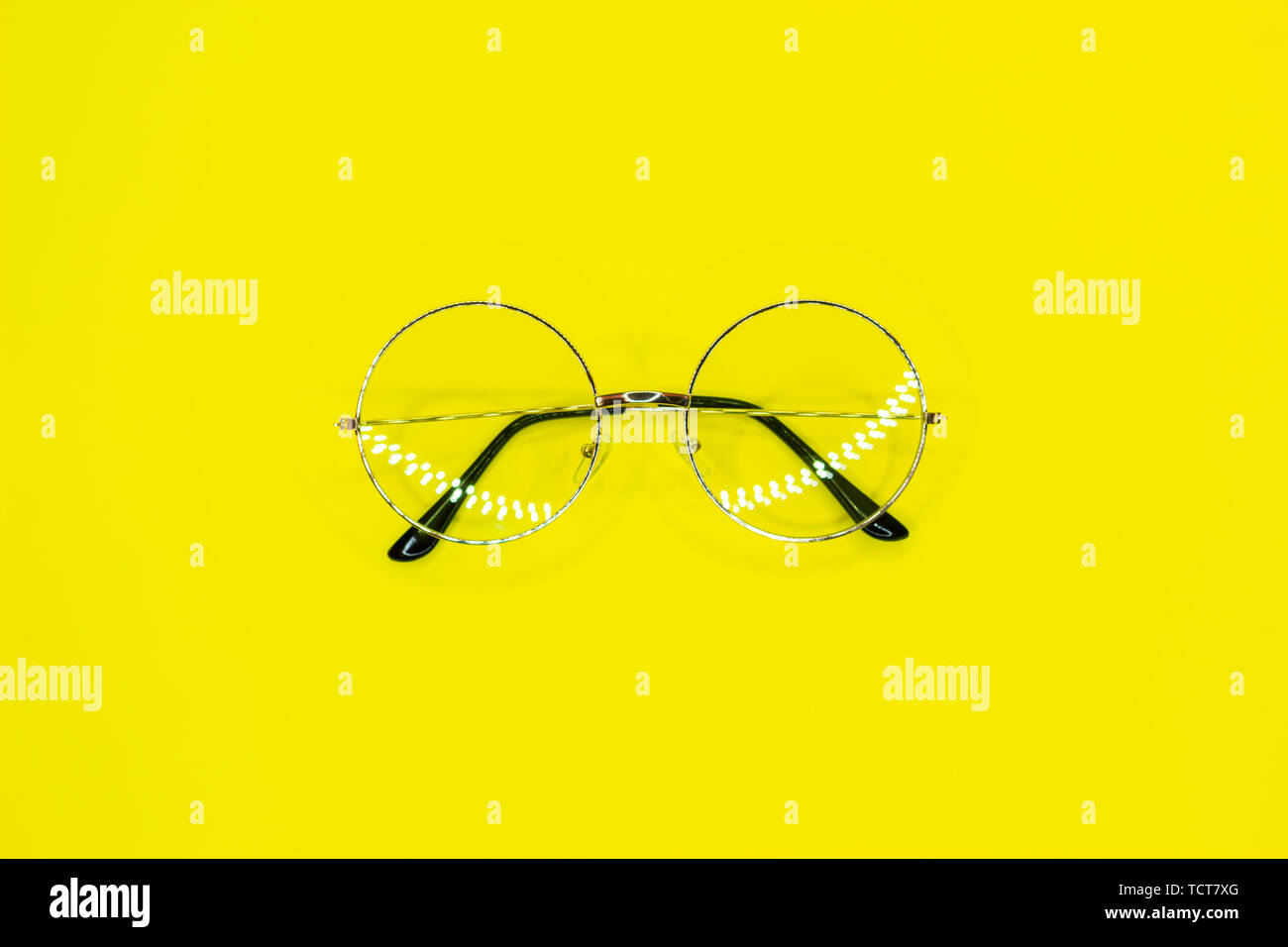 Round glasses on yellow background. Fashion accessory for a clear view ...