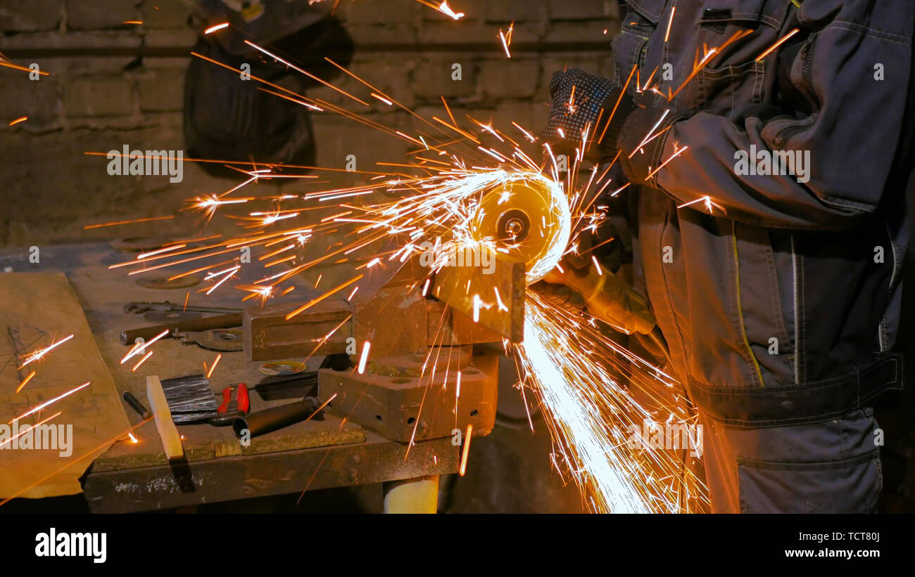 Blacksmith sawing metal with hand circular saw Stock Photo - Alamy