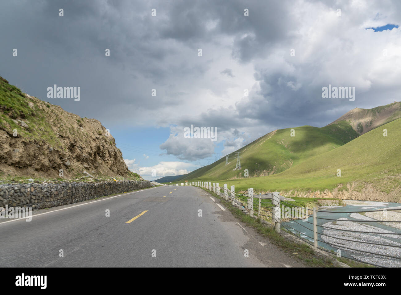 Summer Xinjiang alpine grassland road car background Stock Photo - Alamy