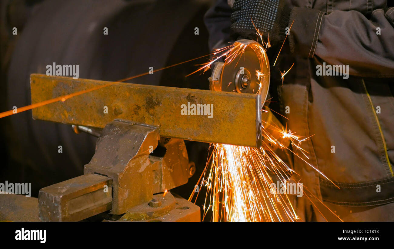 Blacksmith sawing metal with hand circular saw Stock Photo - Alamy