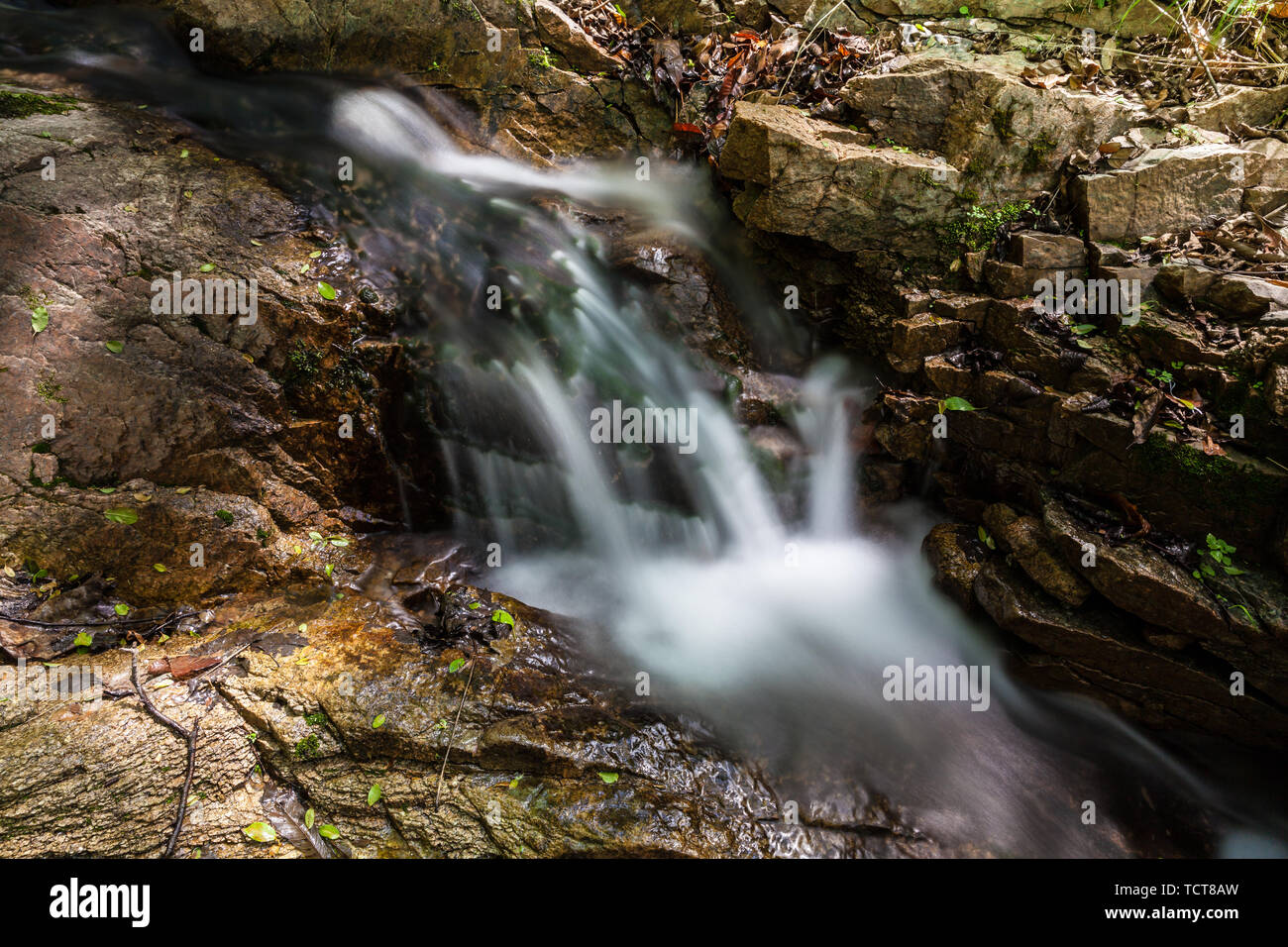 Creek flowing rocks Stock Photo - Alamy