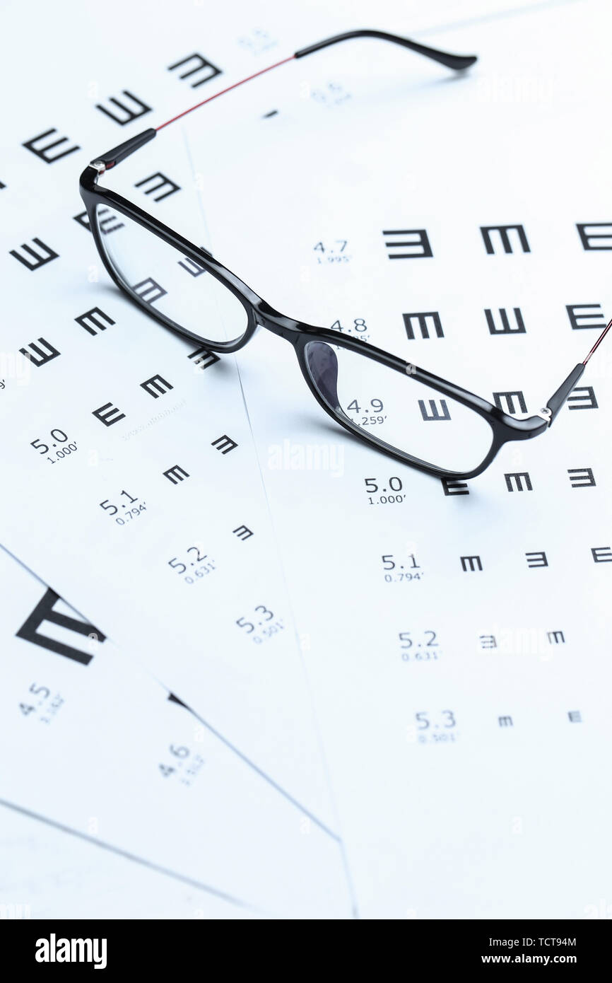 Glasses and eye chart on white background Stock Photo - Alamy