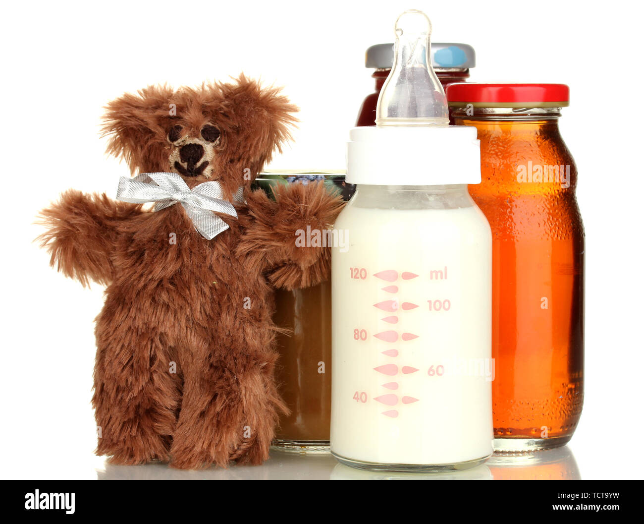 Baby food, bottle of milk and juice with teddy bear isolated on white ...