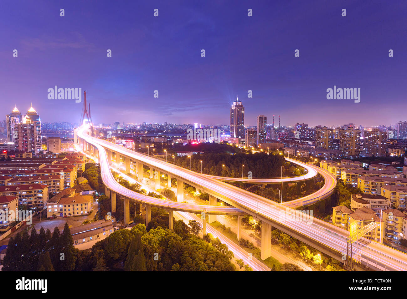 skyline and traffic trails on highway intersection at night Stock Photo ...