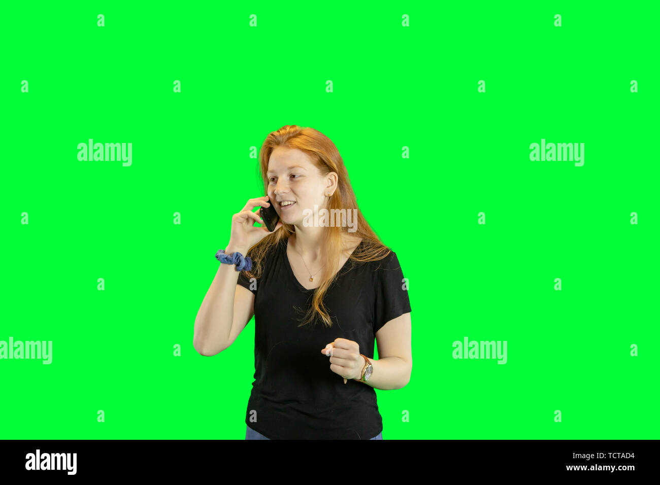 Teen girl with red hair talking on cell phone isolated on white with ...