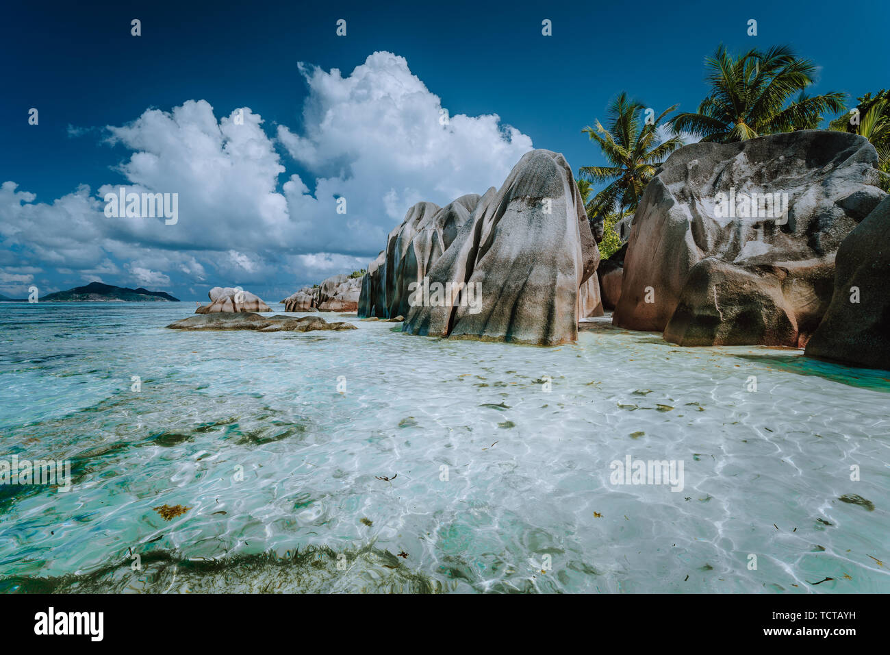 Granite boulders in shallow ocean water and white cloudscape on amazing ...