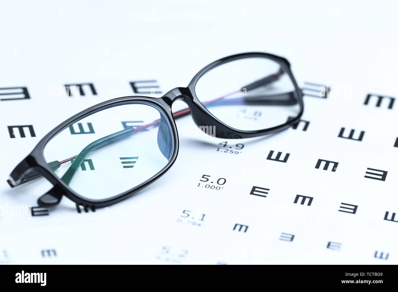 Glasses and eye chart on white background Stock Photo - Alamy