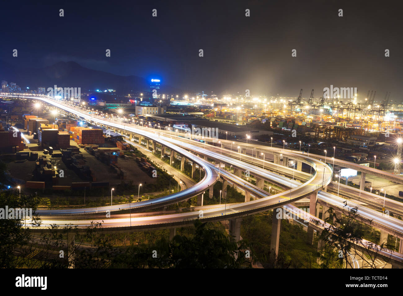 Illuminated and elevated expressway and cityscape at night Stock Photo ...