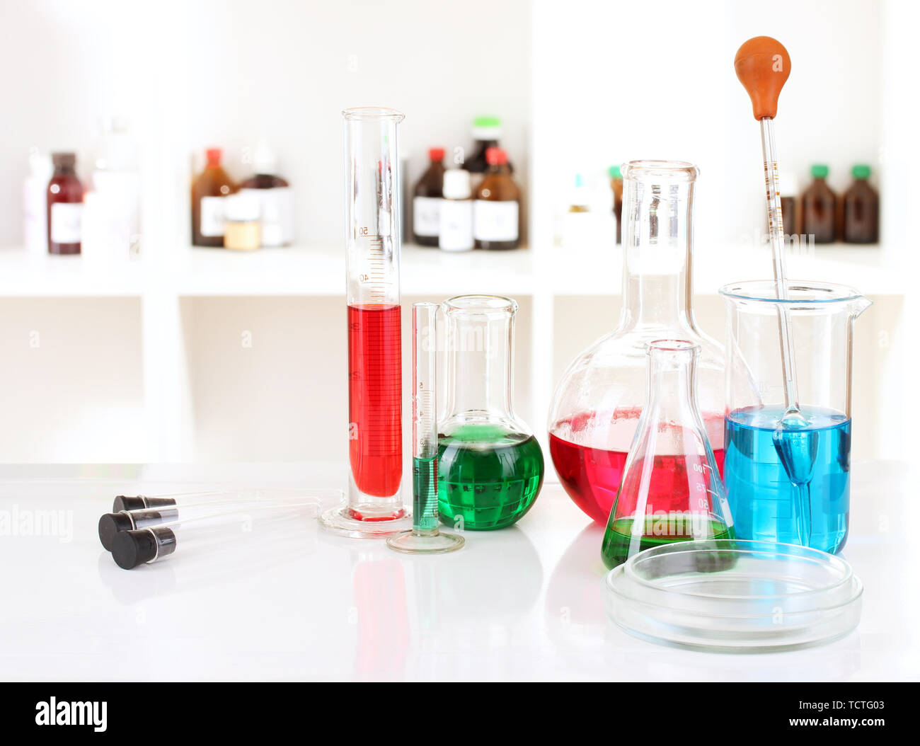 Different laboratory glassware with color liquid on laboratory ...