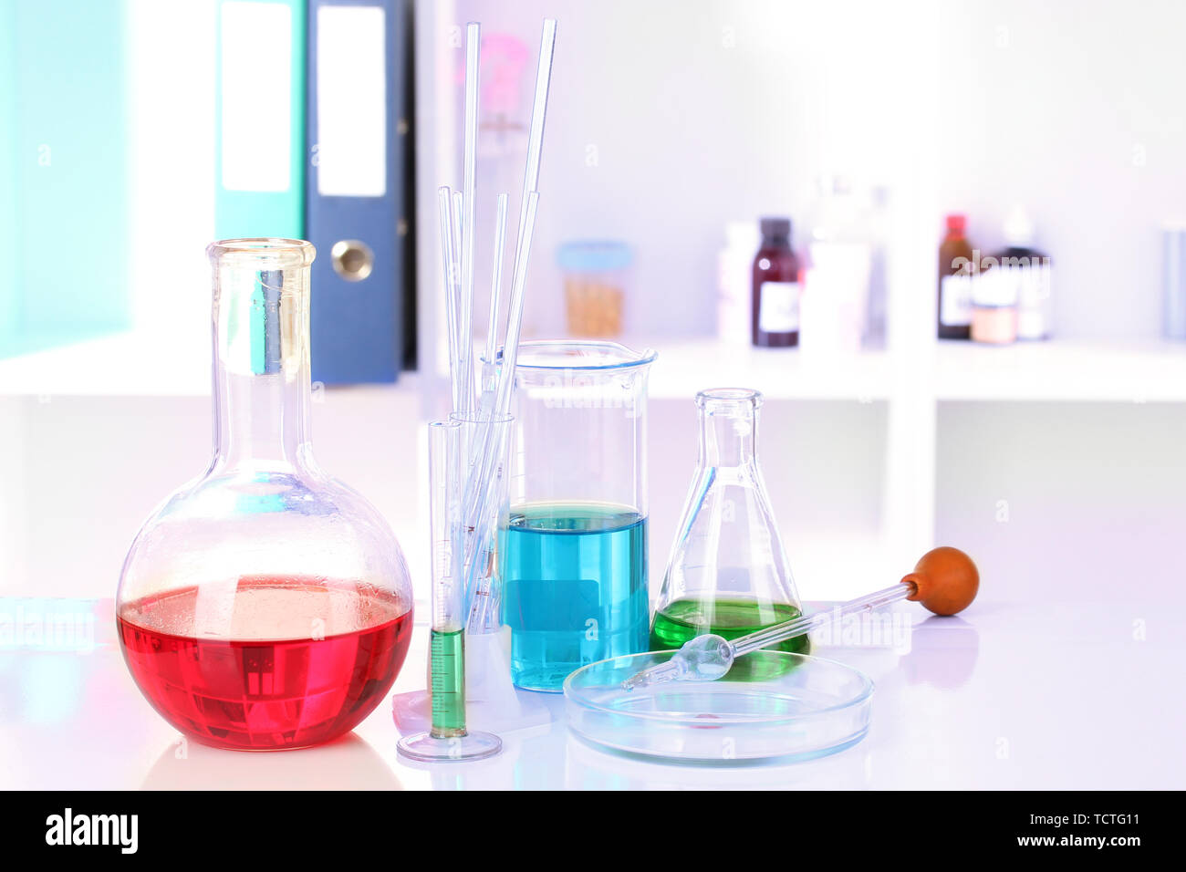 Different laboratory glassware with color liquid on laboratory ...