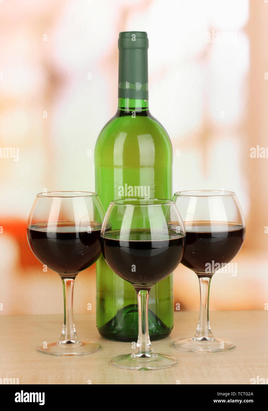 Red wine in glass and bottle on room background Stock Photo - Alamy